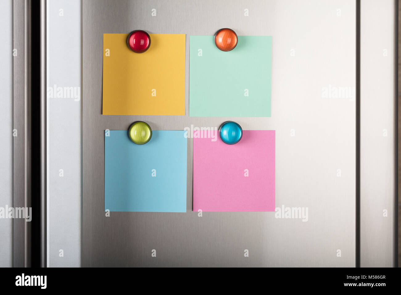 Closeup of blank notes attached with colorful magnetic thumbtacks on ...