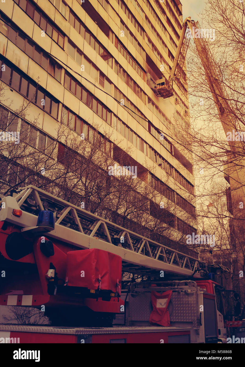 Fire with black smoke in multistory apartment building. Toned Stock ...