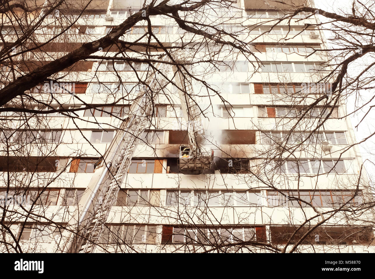 Fire with black smoke in multistory apartment building. Toned Stock ...