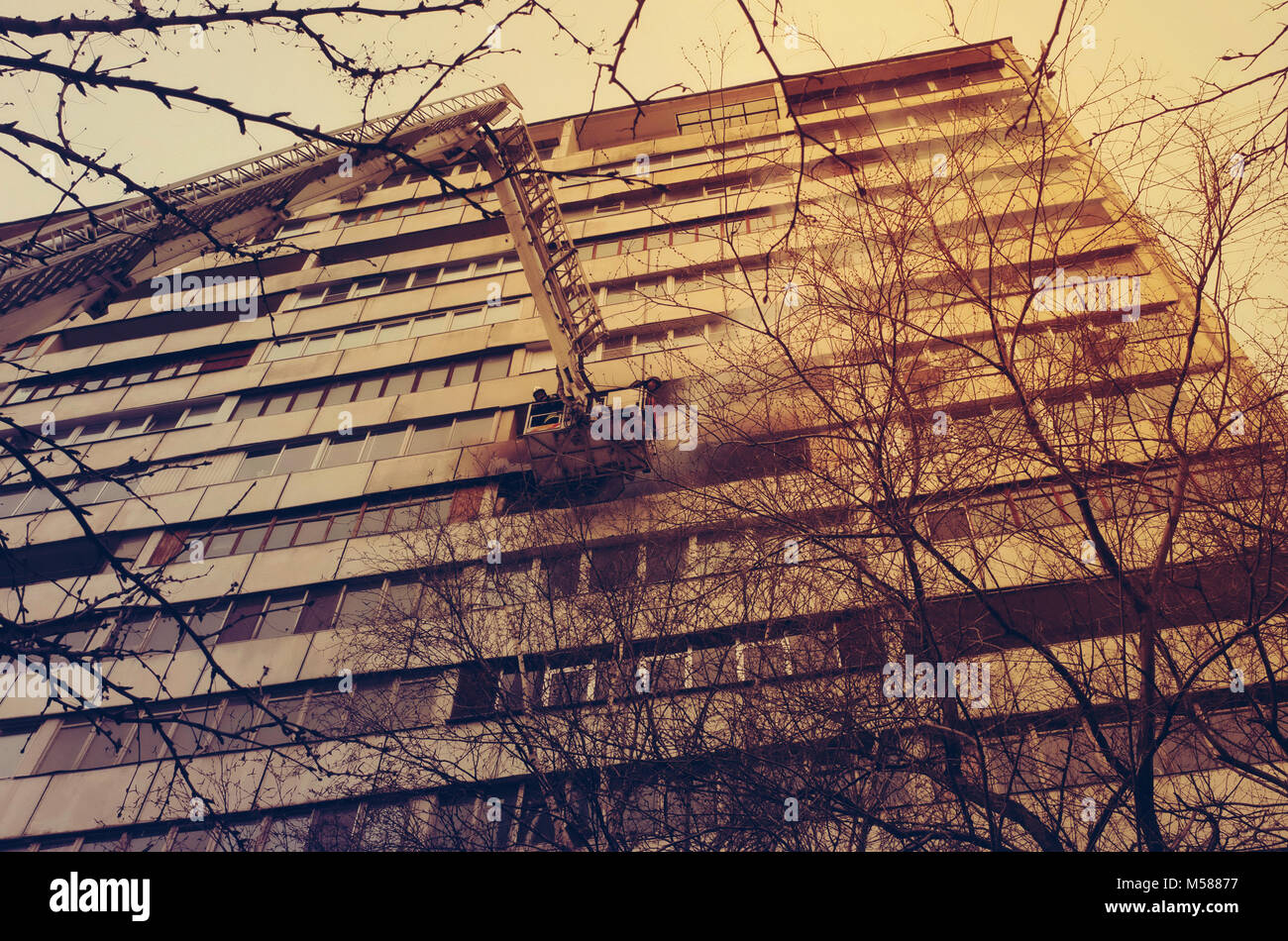 Fire with black smoke in multistory apartment building. Toned Stock ...