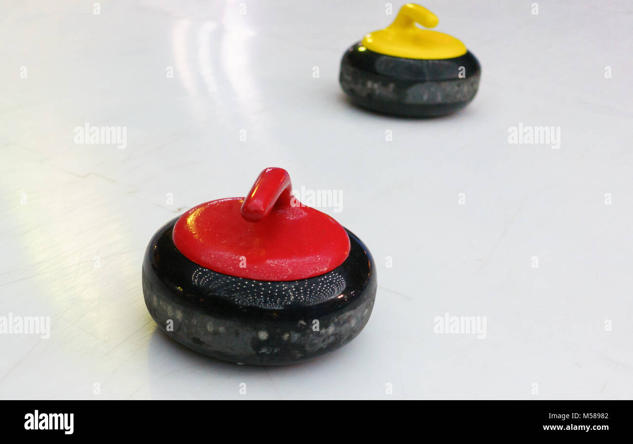 Yellow and red stones for game in Curling Stock Photo - Alamy
