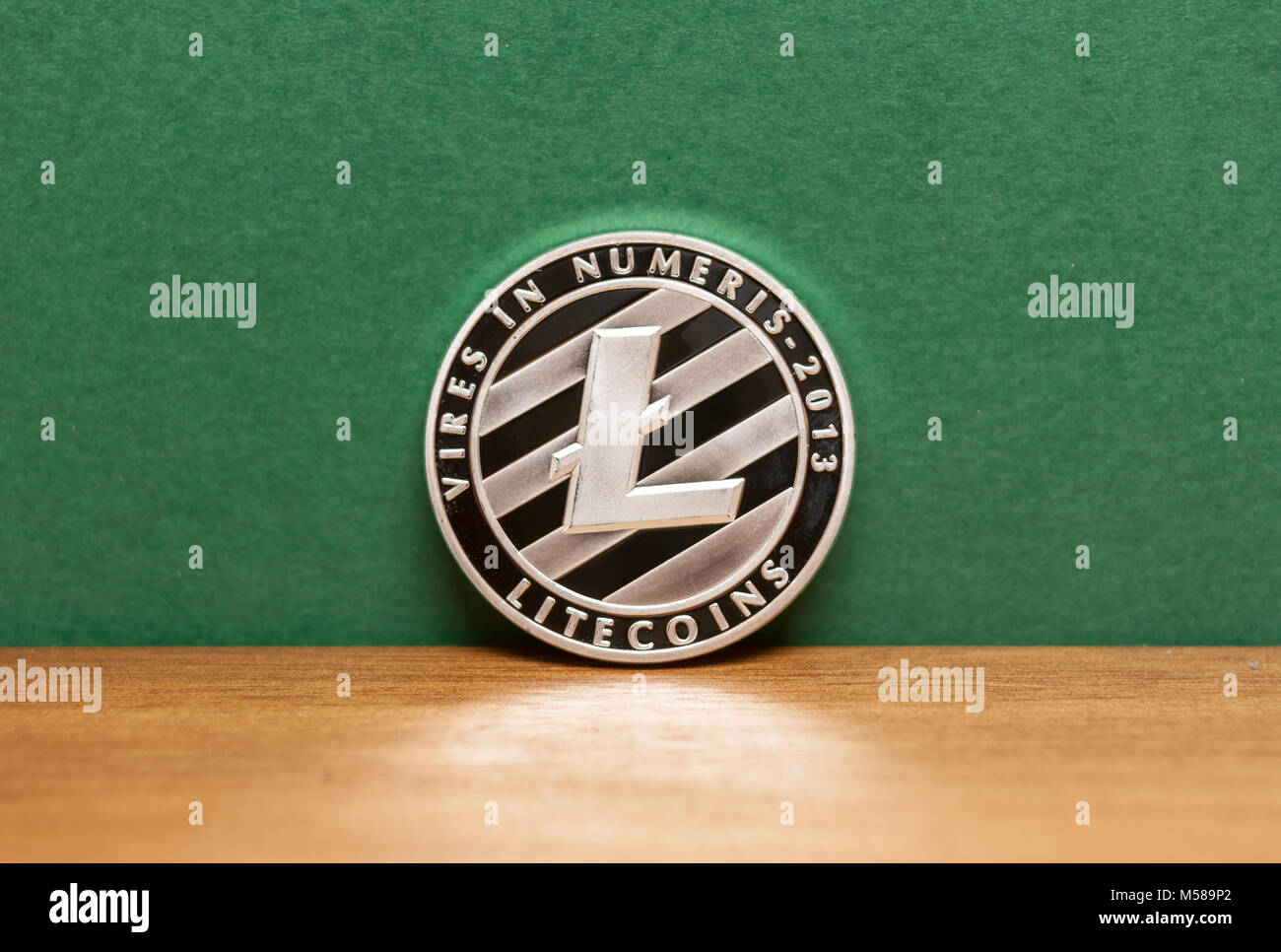 silver litecoin coin green background Stock Photo - Alamy