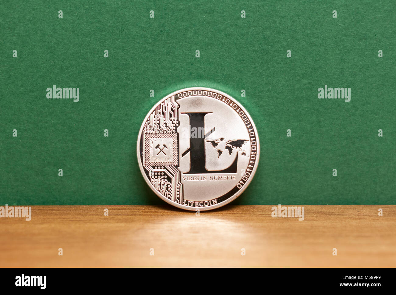 silver litecoin coin green background Stock Photo - Alamy