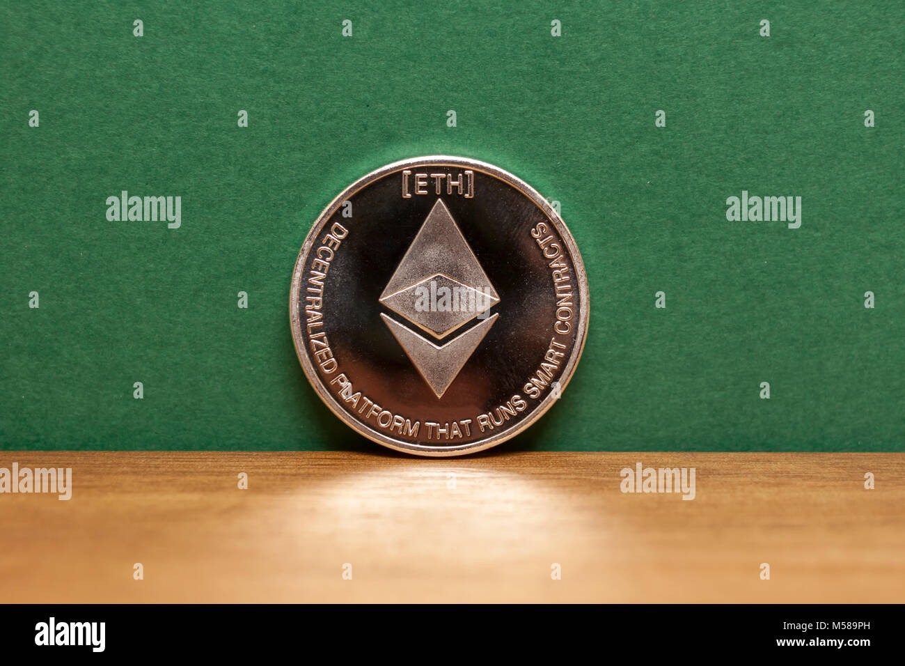 silver ethereum coin green background Stock Photo - Alamy