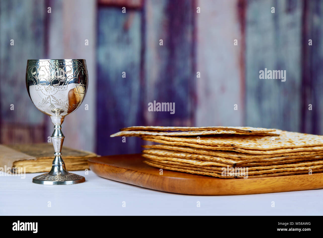 Red kosher wine with a white plate of matzah or matza and a Passover ...