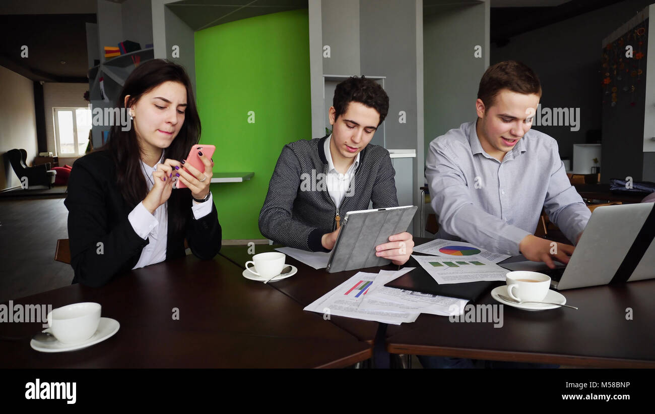 Serious employees of firm, two men and woman are loaded with wor Stock ...