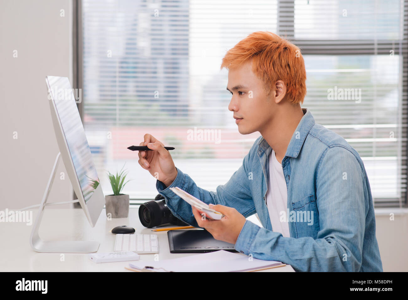 Photographer working at desk in modern office Stock Photo - Alamy