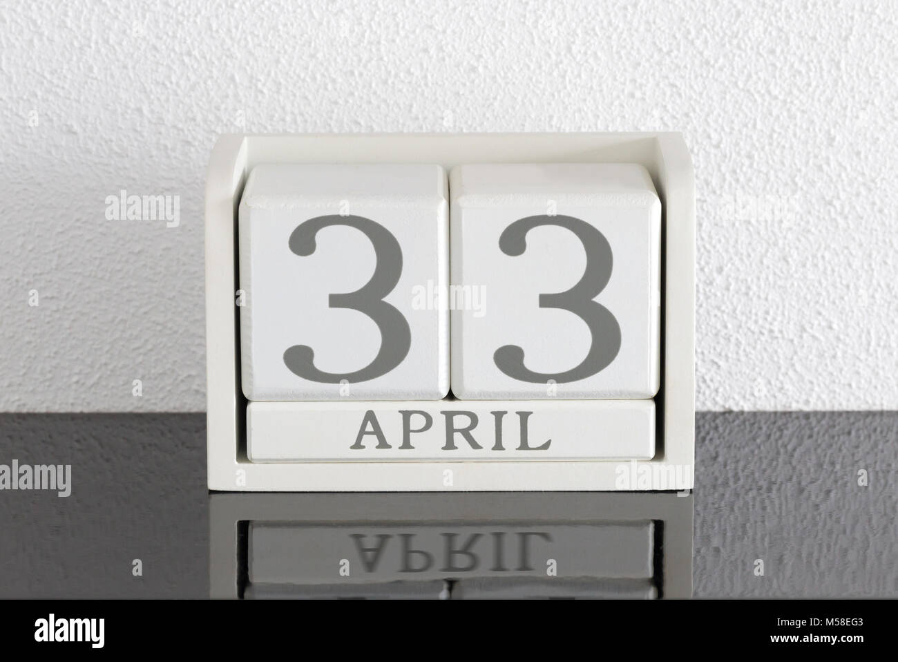 White block calendar present date 33 and month April on white wall ...