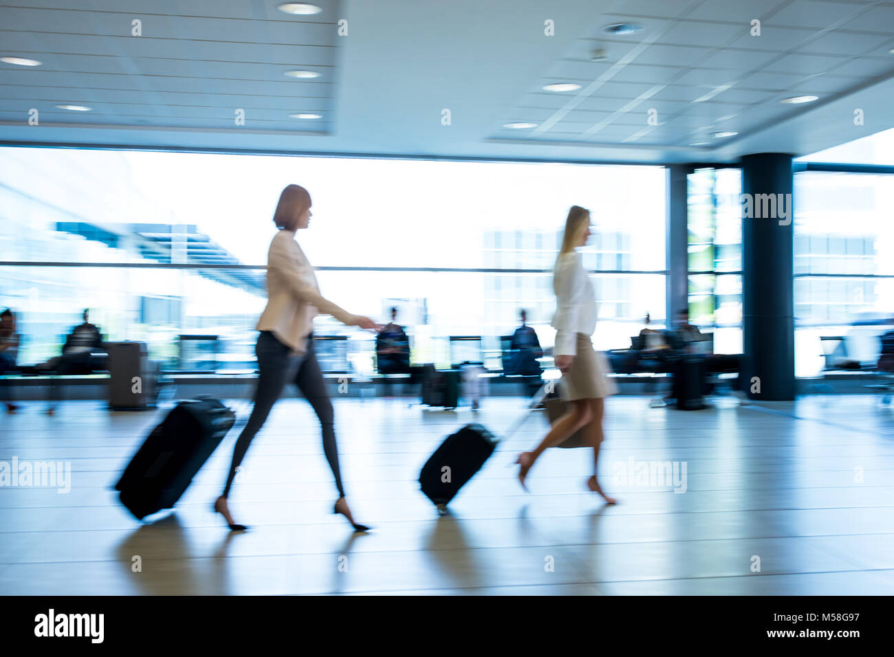 People rushing through a modern airport corridor (color toned image ...