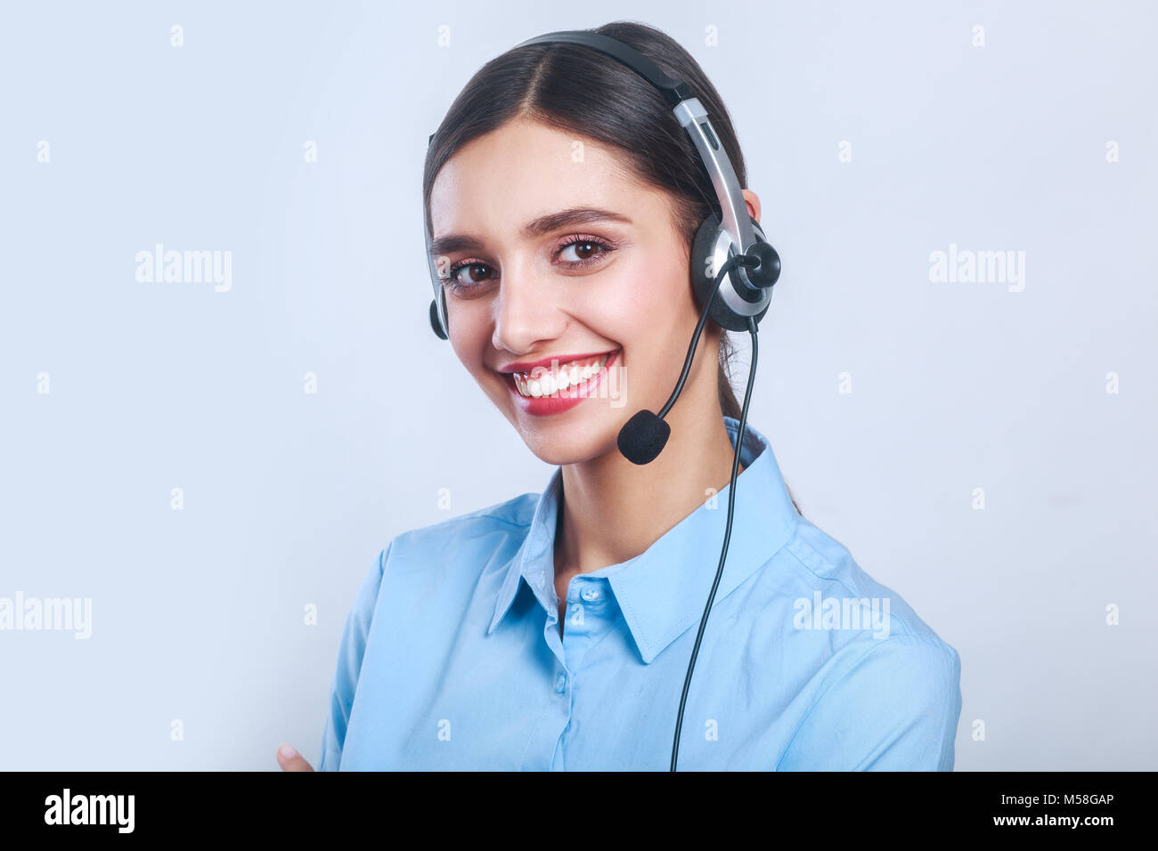 smiling customer support female phone operator in headset, against grey ...