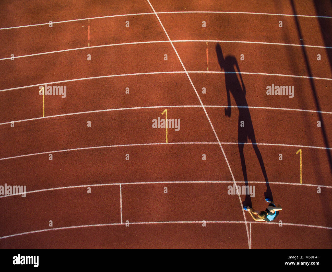 Shot of a young male athlete training on a race track. Sprinter running ...