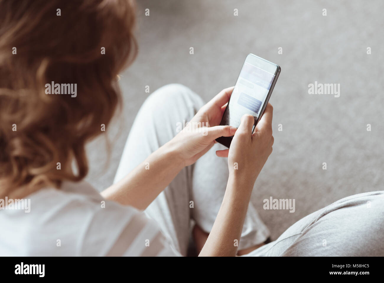 Young woman reading message at home Stock Photo - Alamy