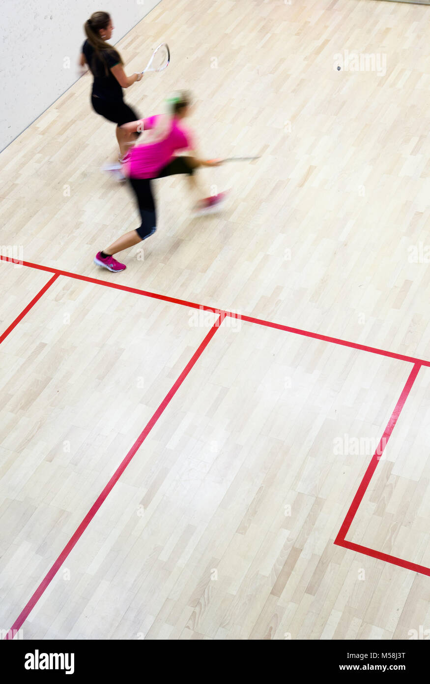 Two female squash players in fast action on a squash court (motion ...