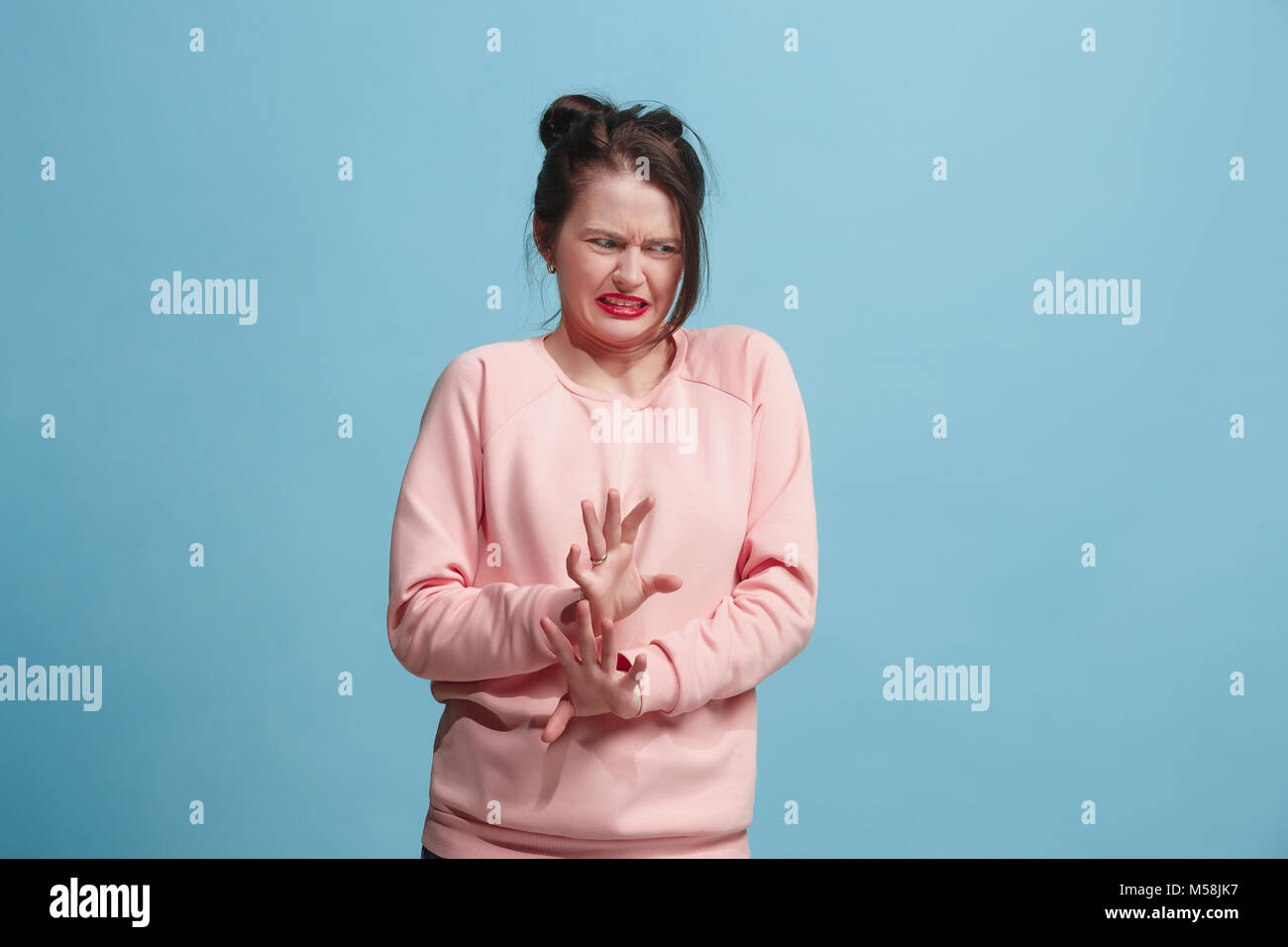 Young woman with disgusted expression repulsing something, isolated on ...