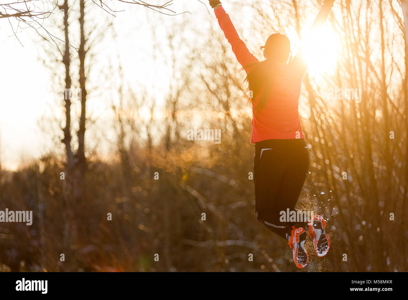 Photo from back jumping female athlete in woods Stock Photo - Alamy