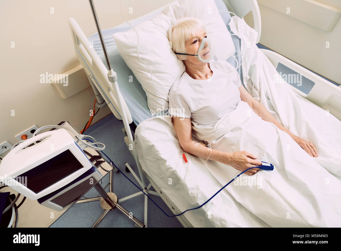 Ill woman with heart rate medical equipment and respiratory support ...