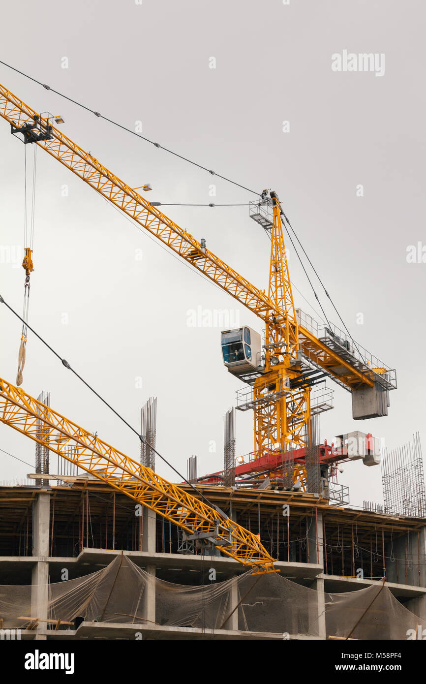 Crane and building under construction on cloudy sky Stock Photo - Alamy