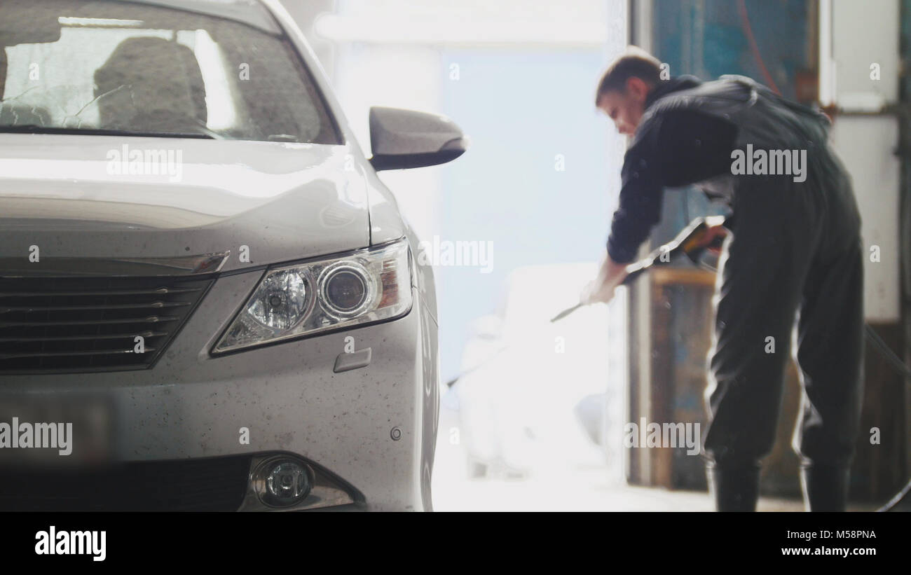Worker washes the car in workshop - manual labour Stock Photo - Alamy