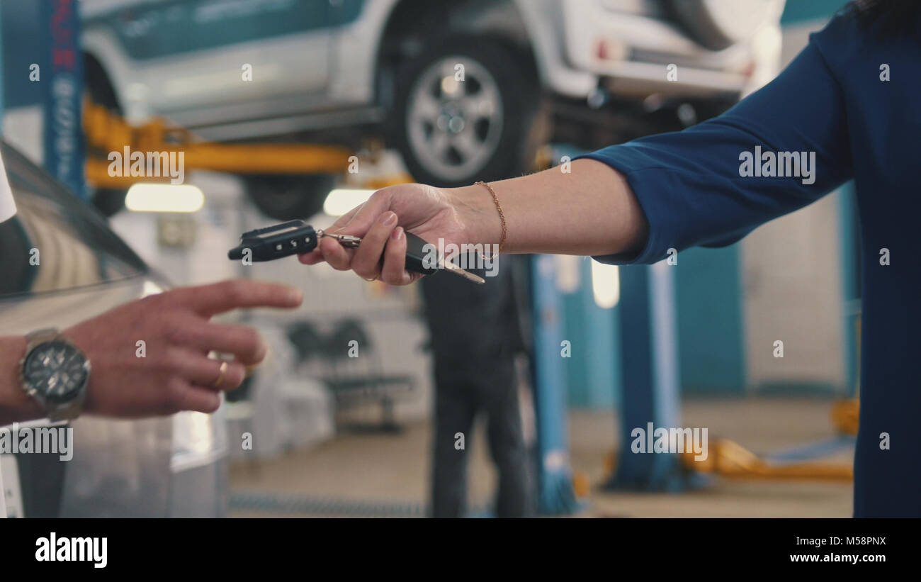 Car workshop - woman gives the keys of car for mechanic Stock Photo - Alamy