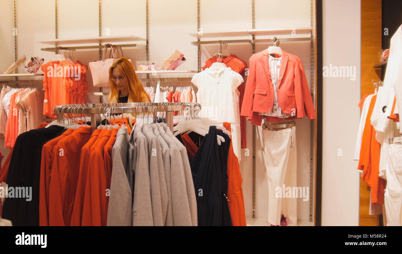 A woman chooses a suit in a women's clothing store Stock Photo - Alamy