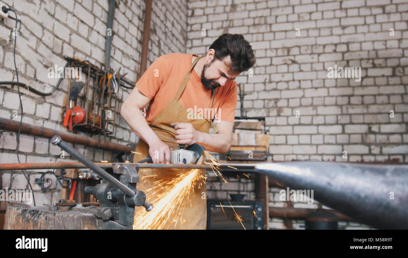Beard man blacksmith forging an knife with circular saw Stock Photo - Alamy