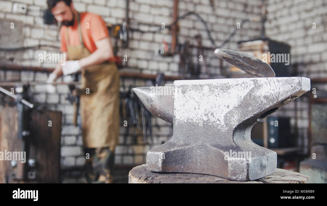 A muscular man working with a circular saw in the forge Stock Photo - Alamy