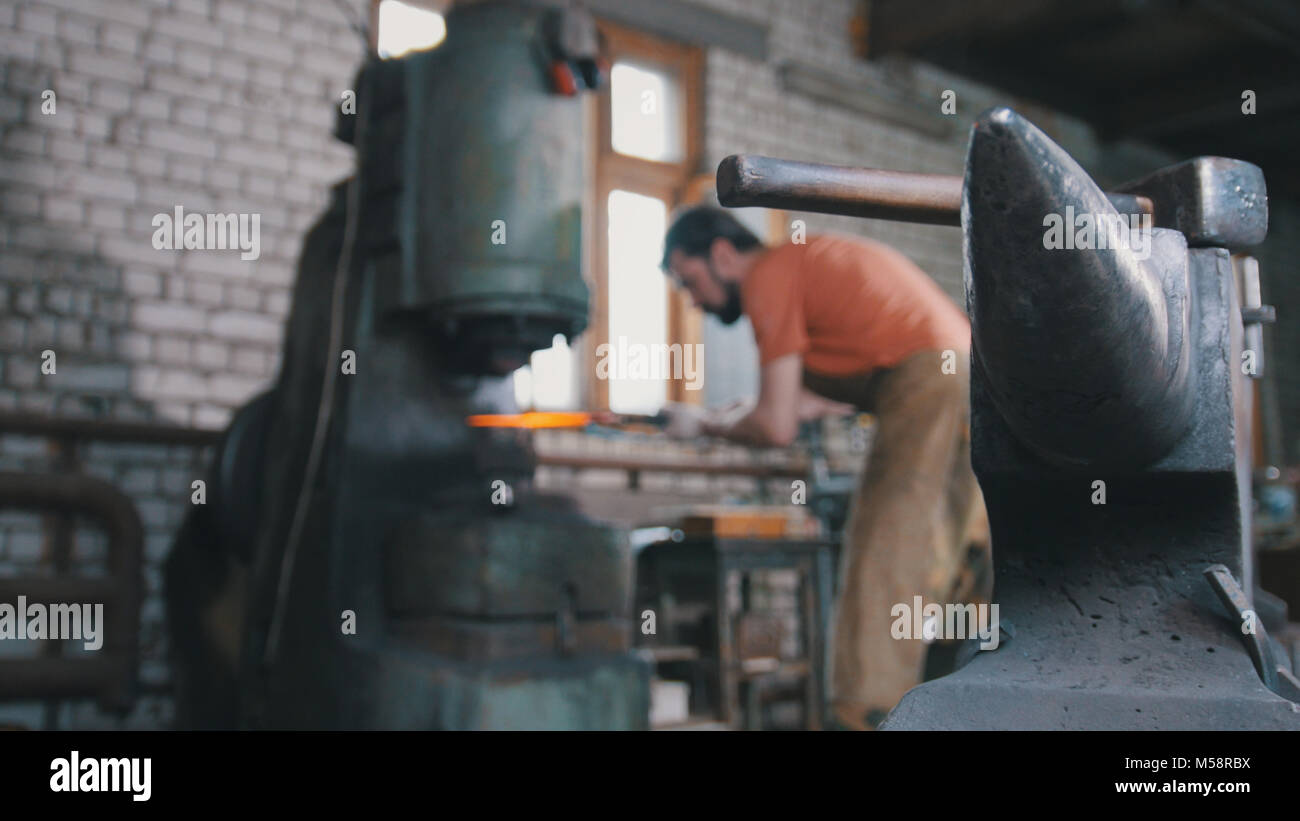 Blacksmith substitutes a metal piece for an automatic hammer Stock ...
