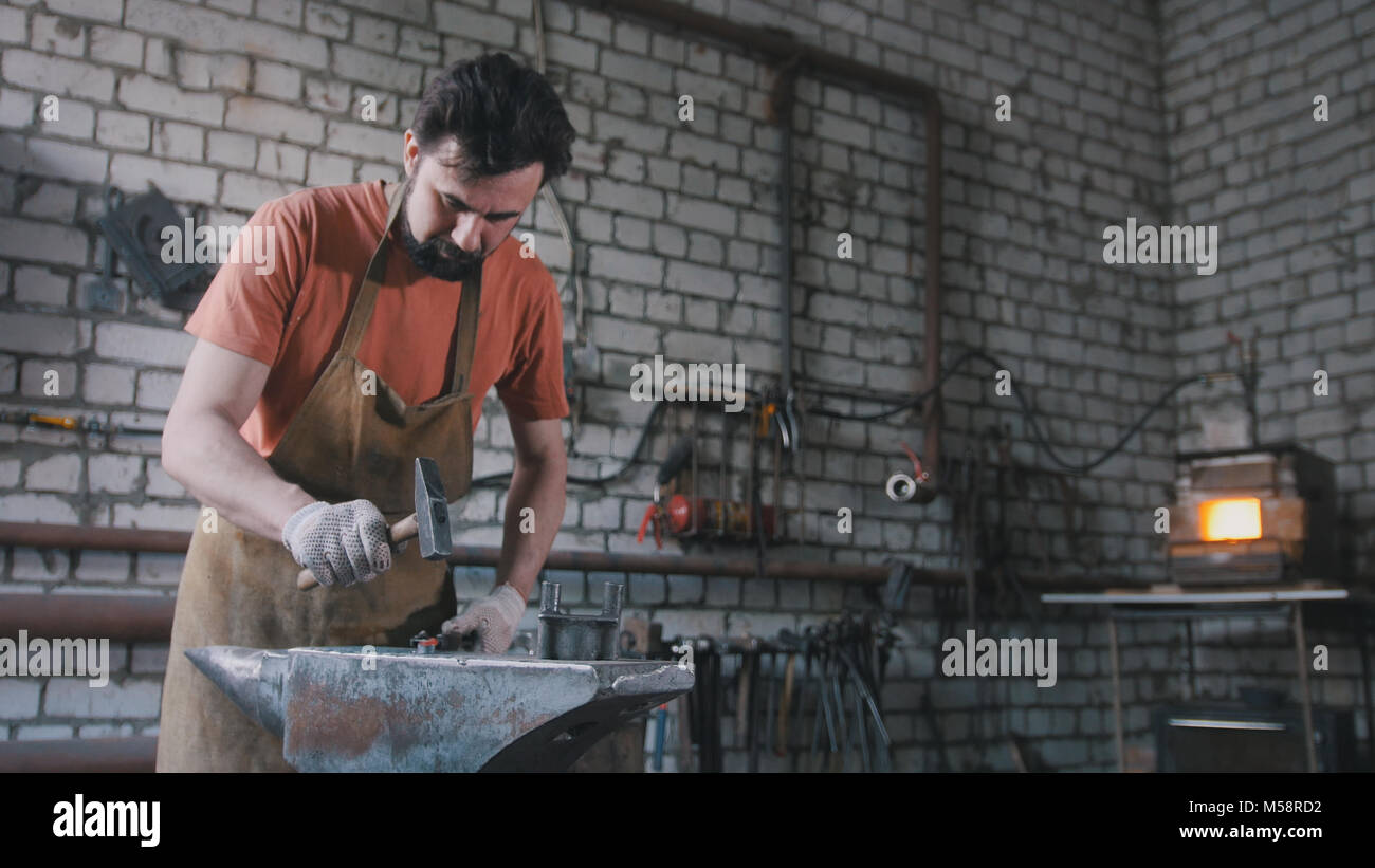 Muscular blacksmith in forge hammering steel products Stock Photo - Alamy