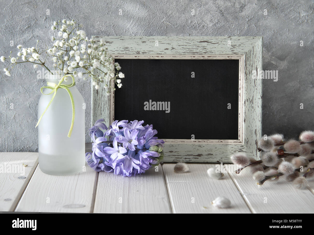 Springtime background. Spring flowers and a blackboard on white table ...