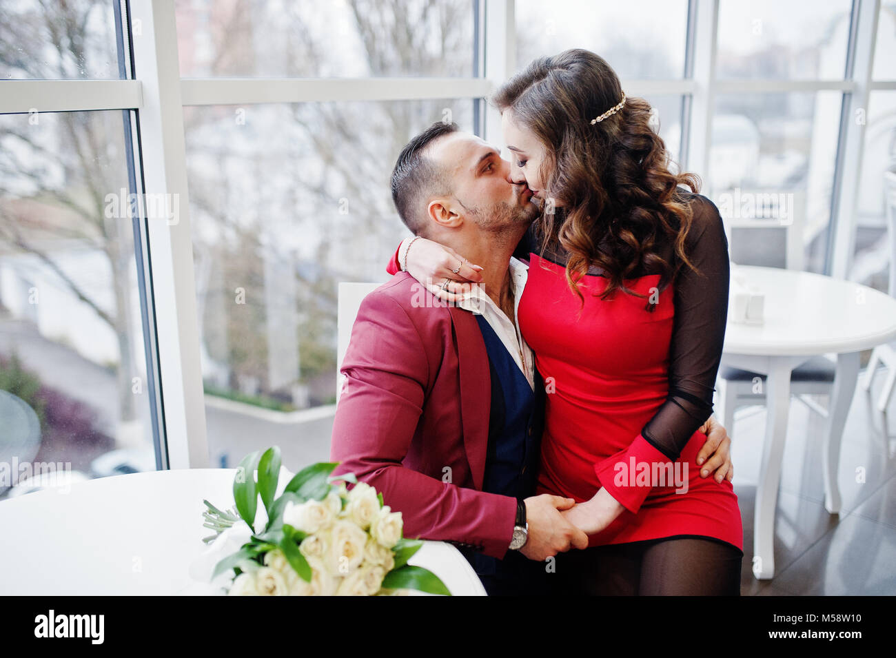 Couple in red love each other at restaurant indoor Stock Photo - Alamy