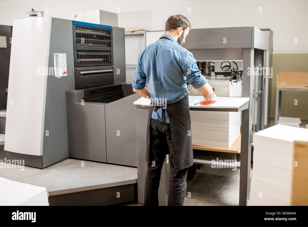 Printing operator working at the manufacturing Stock Photo - Alamy