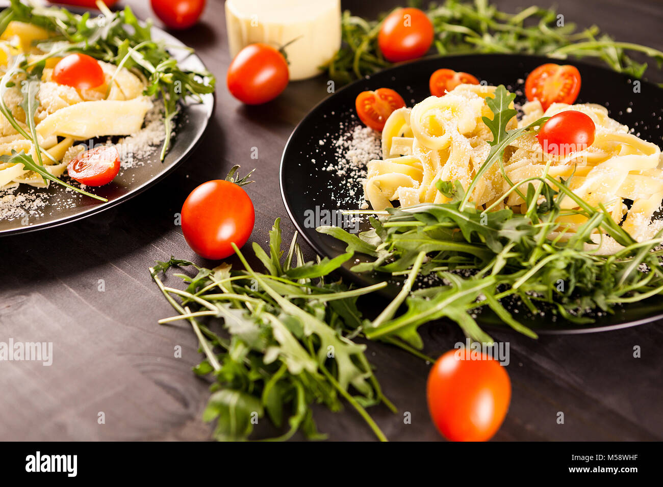 Italian pasta in black plates Stock Photo - Alamy
