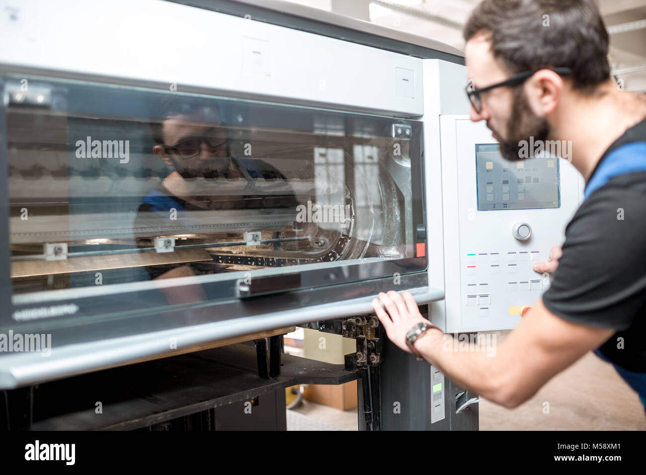 Printing operator working at the manufacturing Stock Photo - Alamy