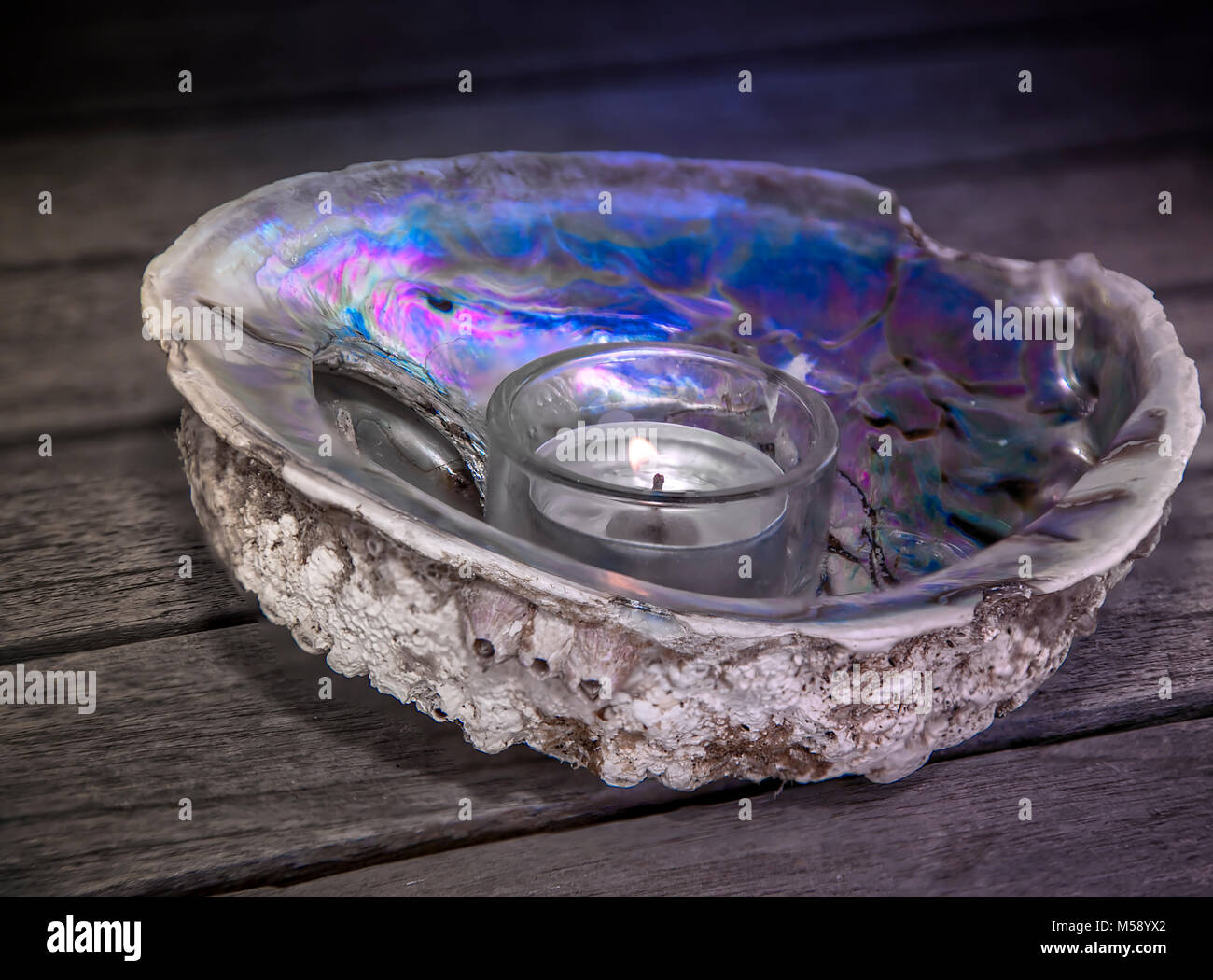 Seashell with Candle . Decorative iridescent Abalone seashell . Close ...
