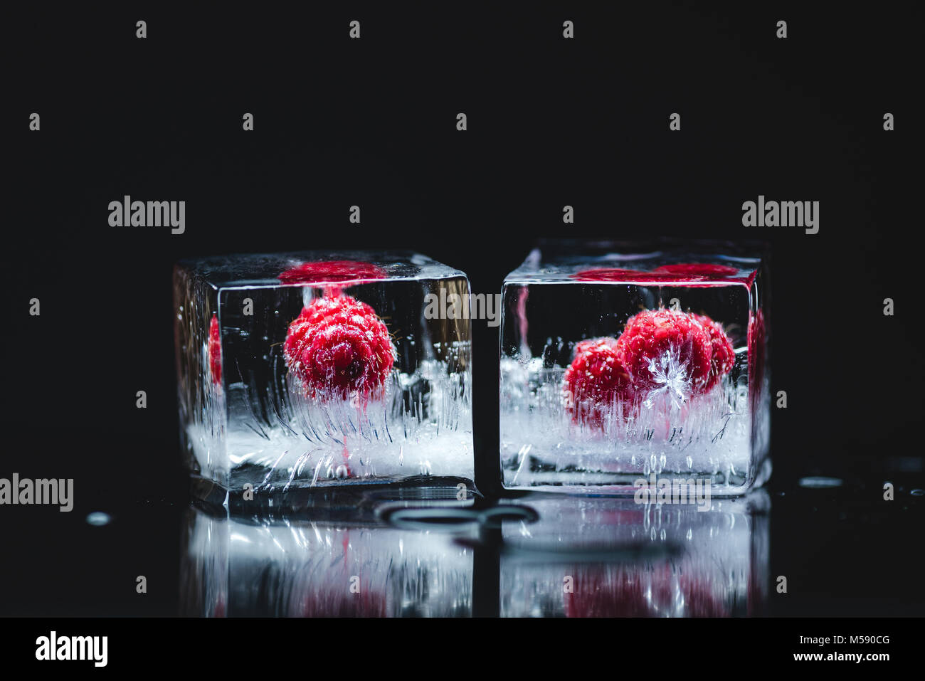 raspberries frozen in ice cubes Stock Photo - Alamy