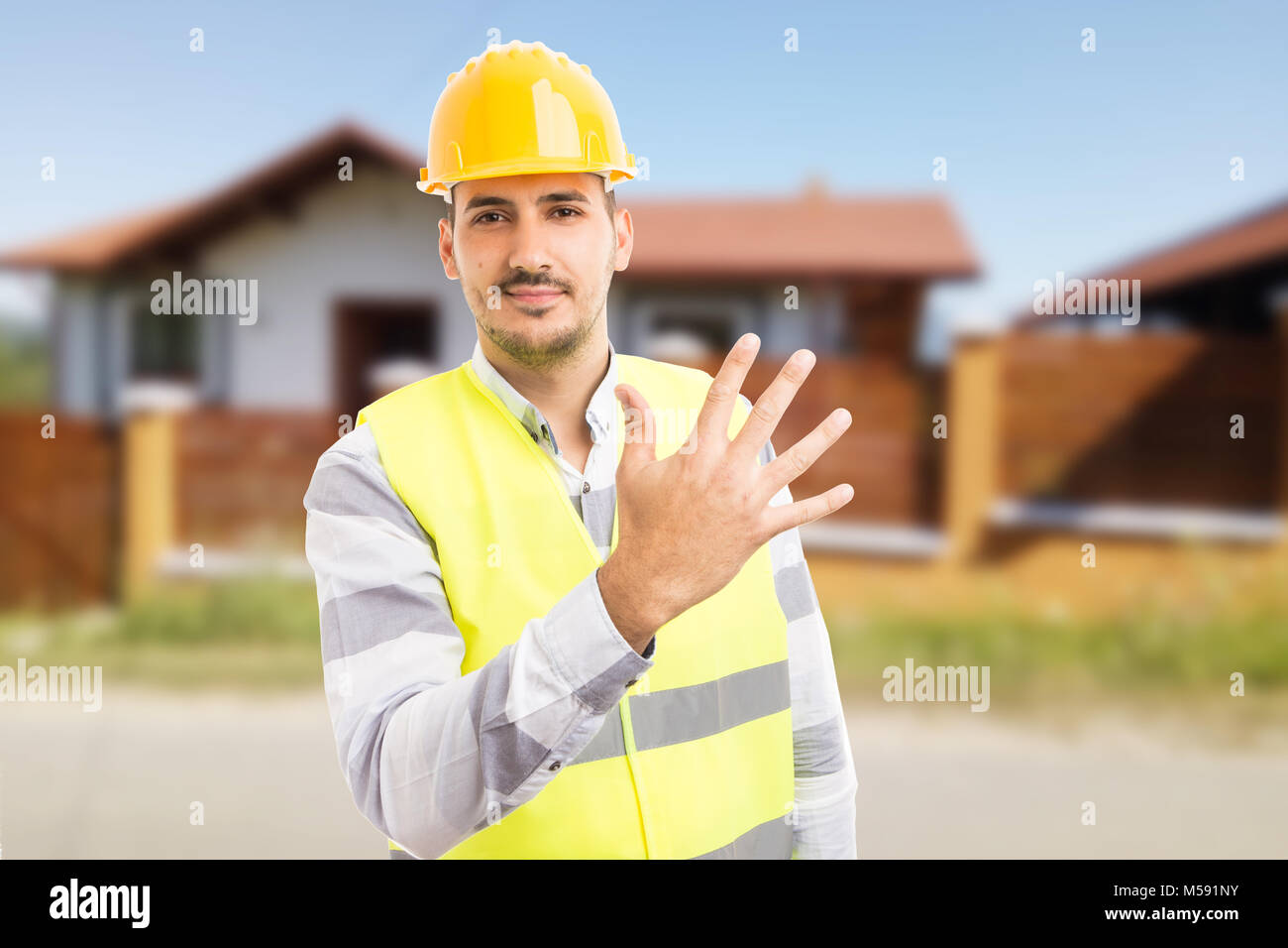 Handsome smiling architect or enginer showing number five in front of a ...