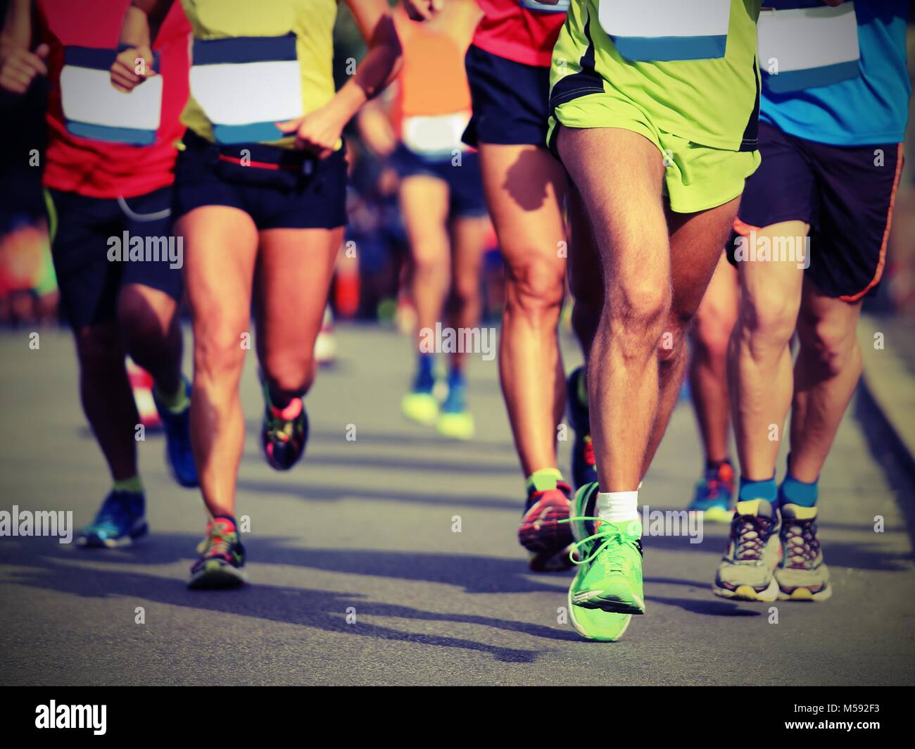 many legs of runners at finish line of an marathon with vintage effect ...