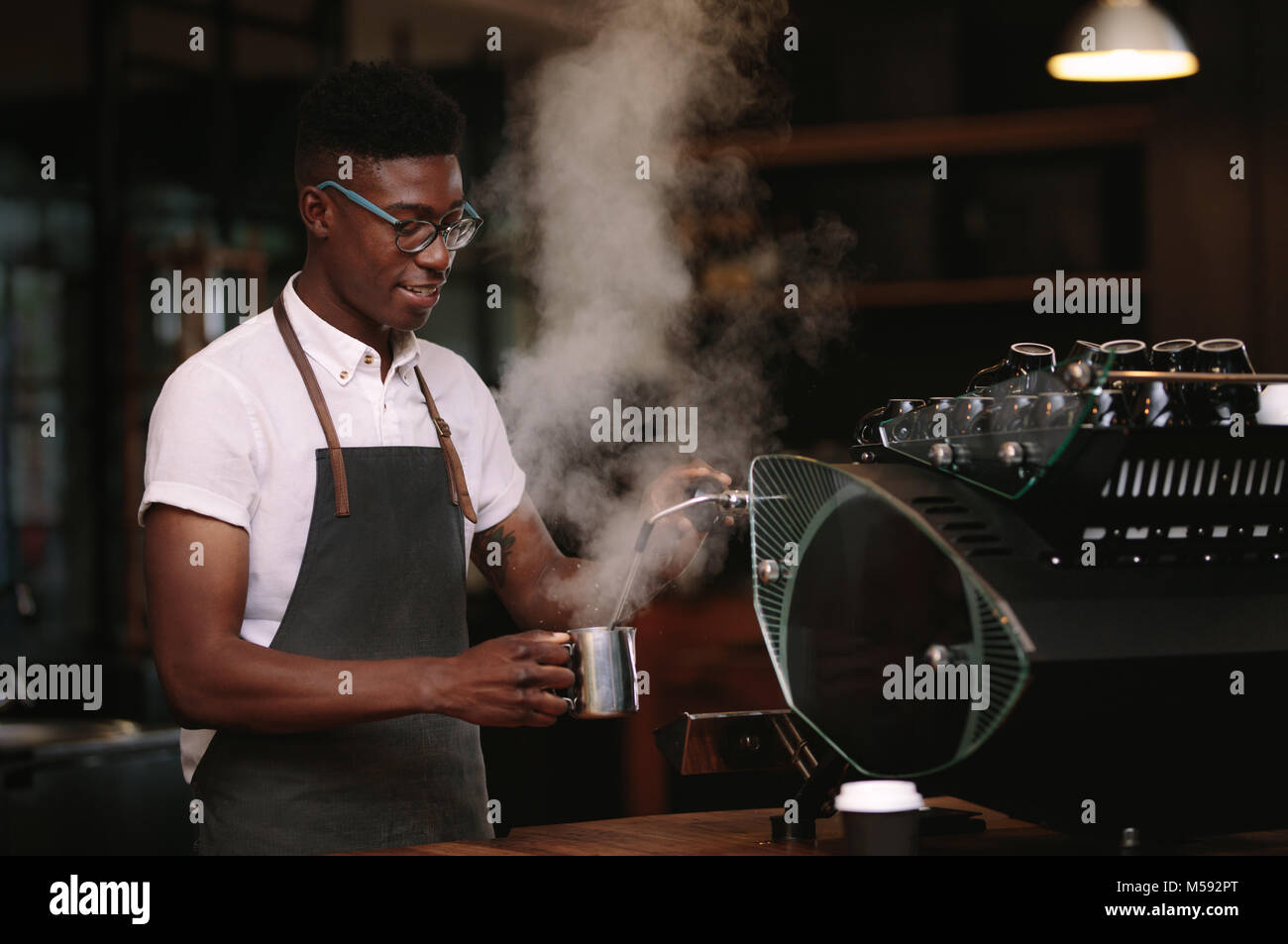 Coffee shop owner preparing coffee on steam espresso coffee machine ...