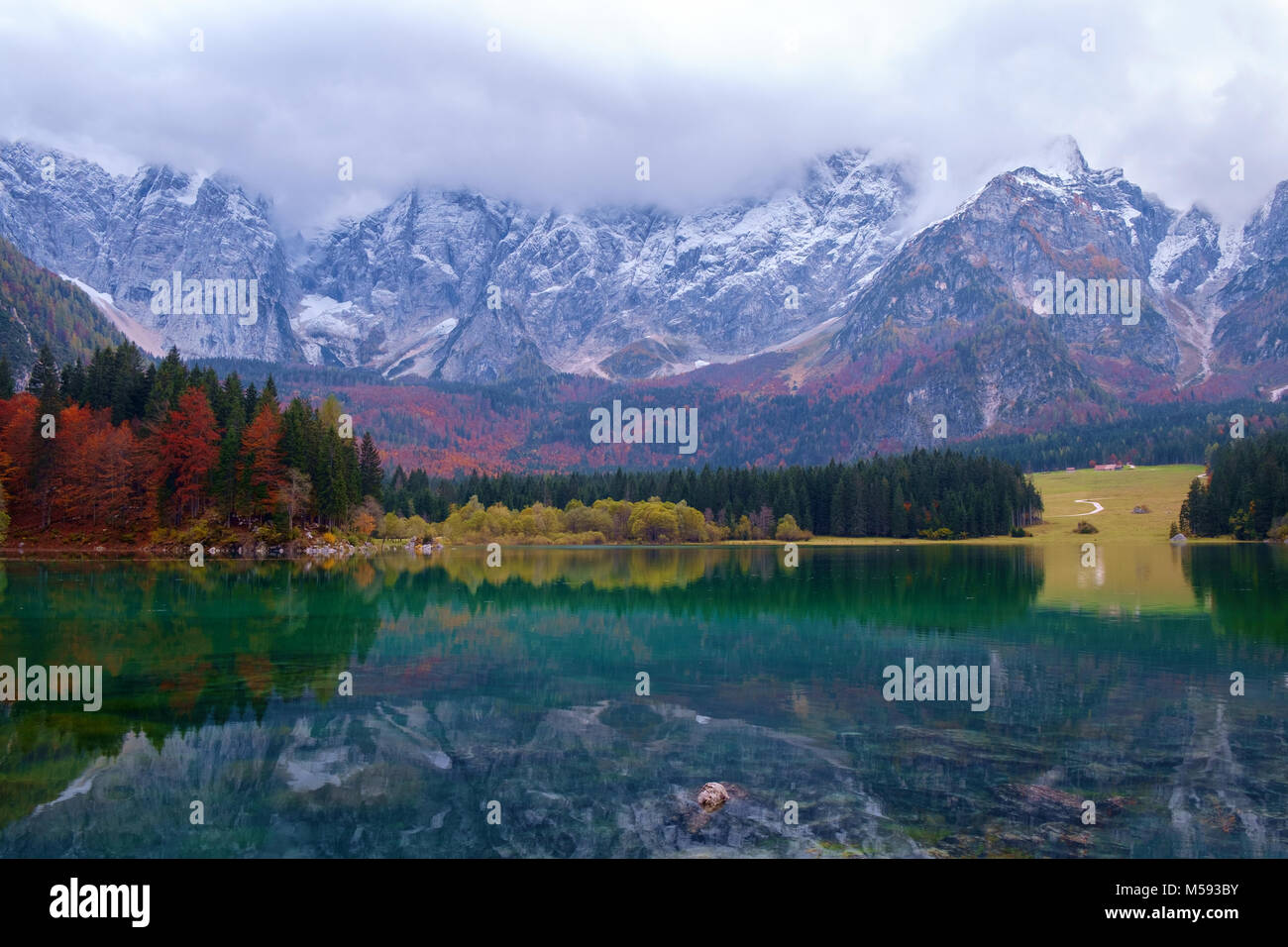 Beautiful Lago di Fusine mountain lake in autumn and Mangart mountain ...