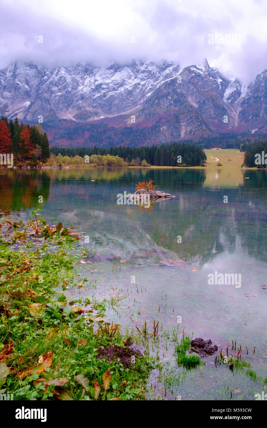 Beautiful Lago di Fusine mountain lake in autumn and Mangart mountain ...