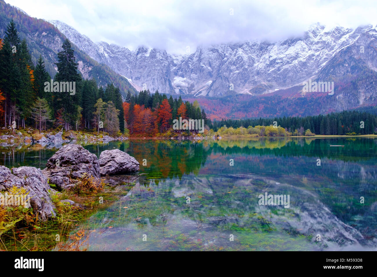 Beautiful Lago di Fusine mountain lake in autumn and Mangart mountain ...