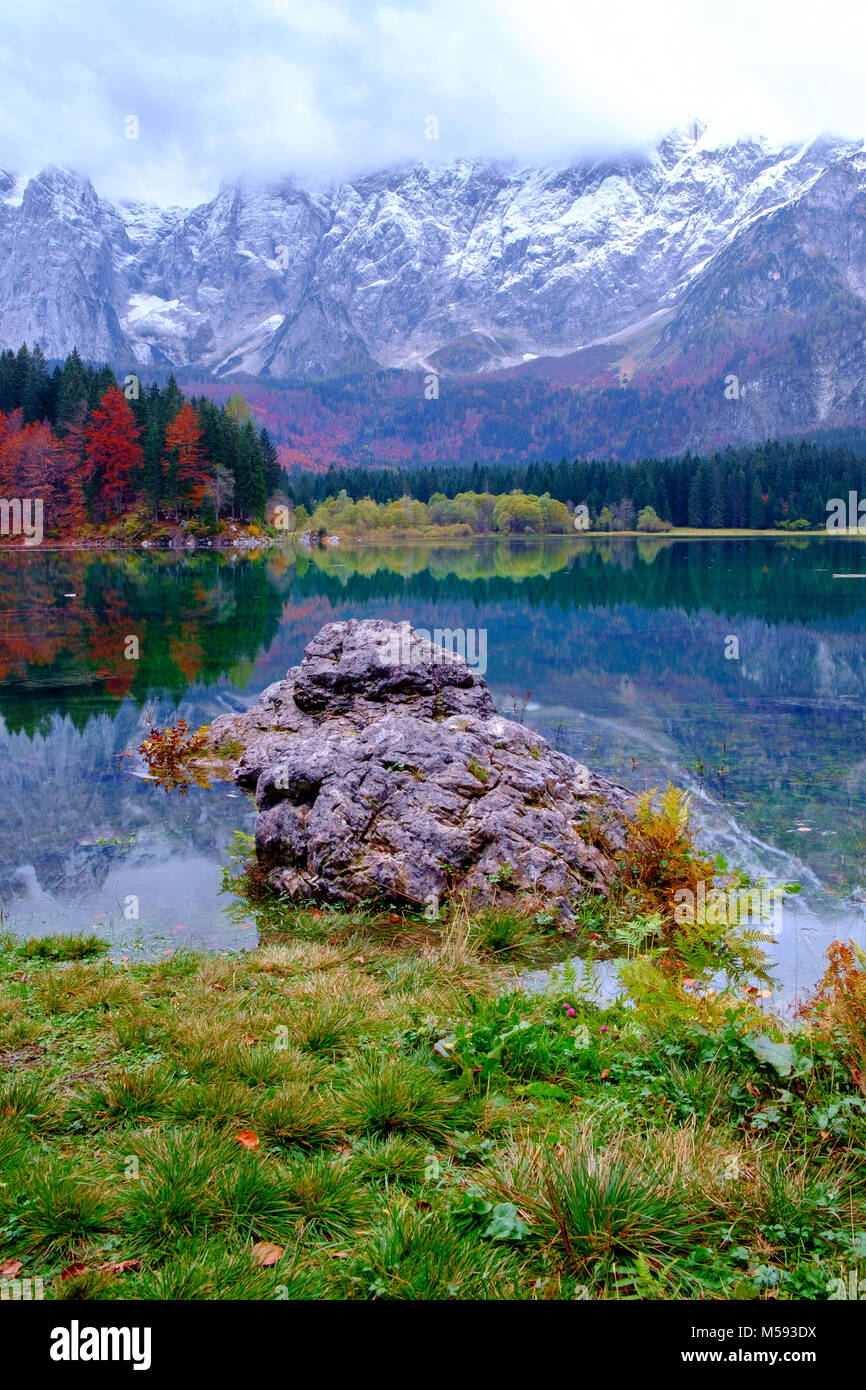 Beautiful Lago di Fusine mountain lake in autumn and Mangart mountain ...