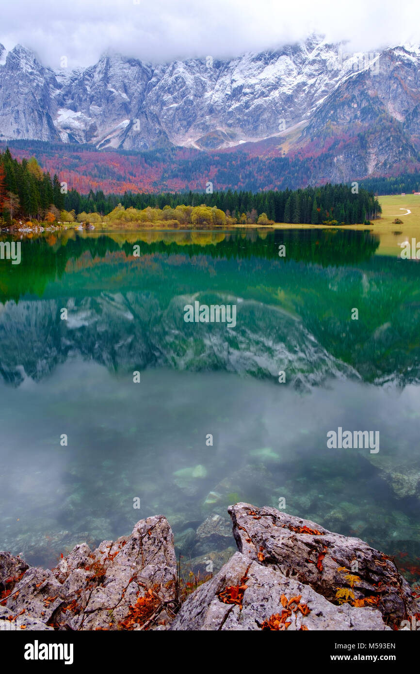 Beautiful Lago di Fusine mountain lake in autumn and Mangart mountain ...