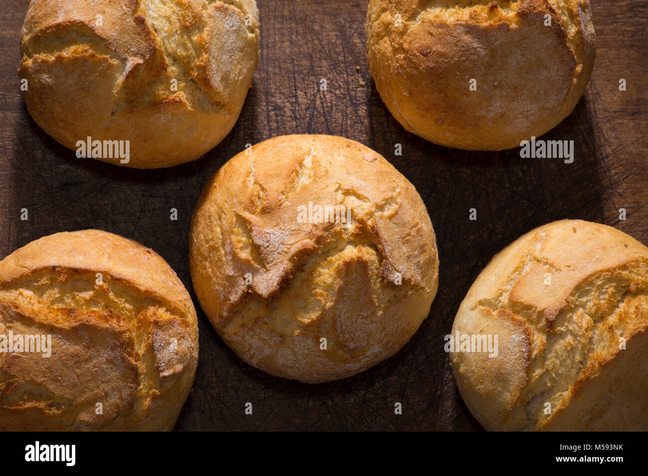 Traditional rustic bread rolls on a vintage cutting board Stock Photo ...