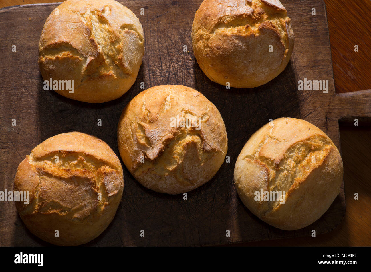 Traditional rustic bread rolls on a vintage cutting board Stock Photo ...