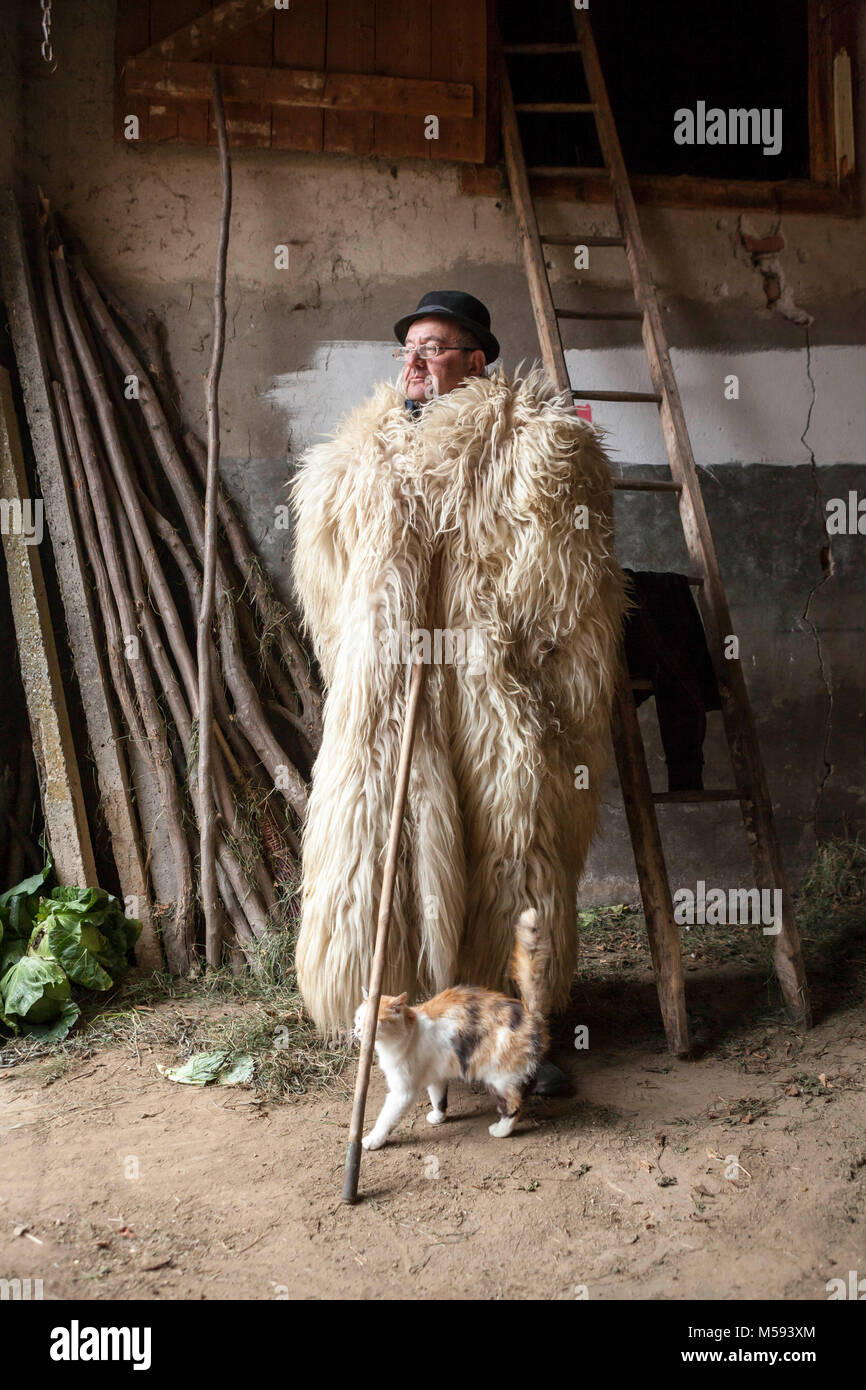 Romanian shepherd wearing a traditional coat made from sheep skins ...