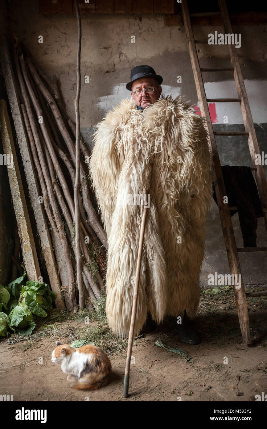 Romanian shepherd wearing a traditional coat made from sheep skins ...