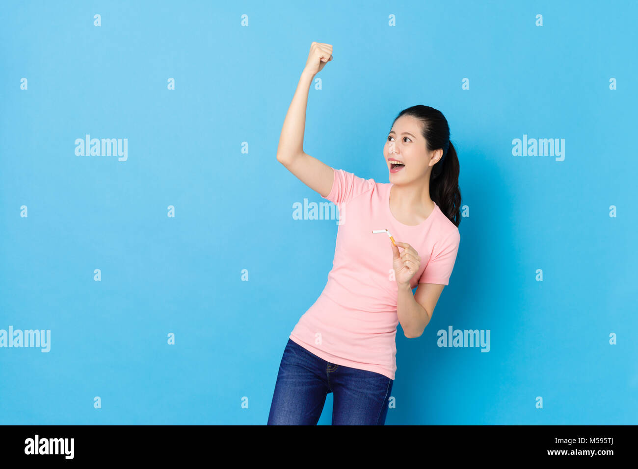 cheerful pretty woman successful quit smoking and standing in blue ...