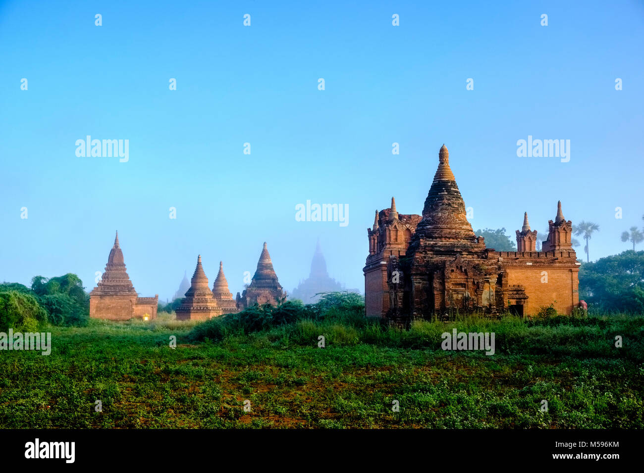 Pagodas of Bagan in the foggy plains of the archaeological site after ...