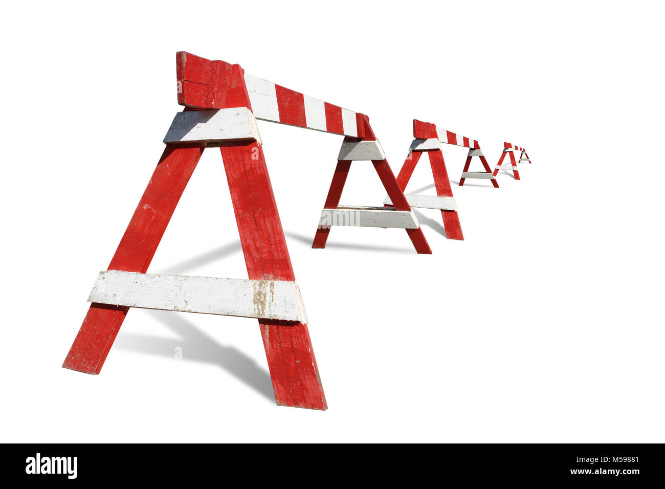 Row of wooden red and white striped road construction barriers ...